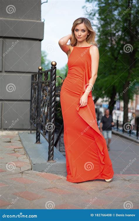 Blue Eyed Blonde Girl With A Beautiful Figure In A Red Dress Posing On