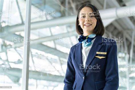 공항 터미널에서 자신감 있는 얼굴과 행복으로 카메라를 바라보며 미소짓고 있는 아름다운 백인 승무원의 초상화 모든 고객 또는 승객을 비행기에 환영합니다 승무원 교통 관련