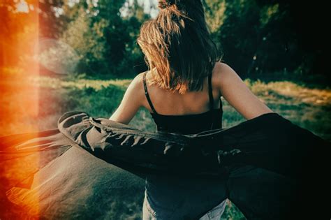 놀라운 태양 광선 대기 순간에 햇볕이 잘 드는 공원에서 재미를 가진 세련된 힙스터 소녀 저녁 빛 백 뷰에서 춤을 추는 세련된 멋진 여성 선택적 초점 복고풍 효과 크리에이티브