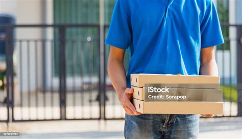 음식 주문과 아시아 젊은 배달 남자 택배 온라인 피자 상자 는 제복 그 보호 얼굴 마스크 통행 금지 검역 전염병 전염병 코로나