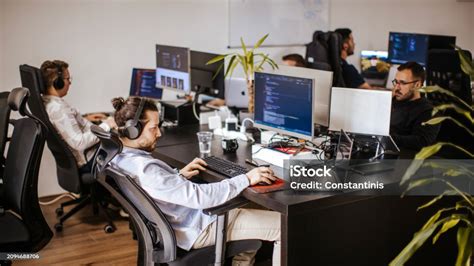 Group Of Male And Female Computer Programmers Working On Computer At The Open Space Office Stock