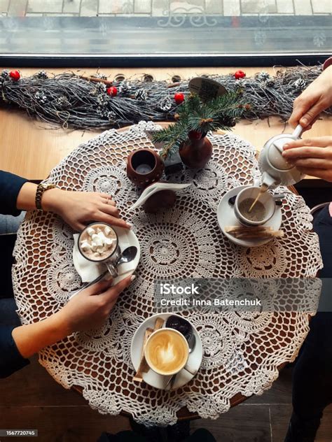 흰색 빈티지 크로 셰 뜨개질 식탁보 커피 음료 3 잔 두 여성의 손이있는 원형 테이블의 위에서 수직으로 똑바로 촬영 창턱에