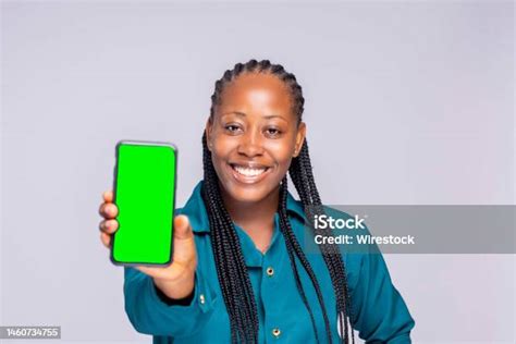 젊은 아프리카 여성은 얼굴에 미소를 지으며 스마트폰 화면을 보여줍니다 개념에 대한 스톡 사진 및 기타 이미지 개념 개념과 주제 공란 Istock