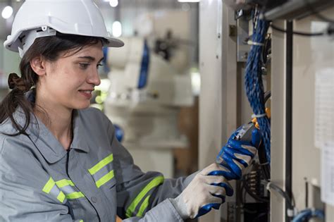여성 전기 기술자 점검 수리 유지 보수 작업 전기 시스템 공장에서 생산 라인에서 작동 전기 시스템을 다루는 여성 전기 기사