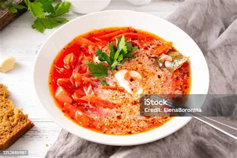 흰색 배경에 회색 냅킨에 흰색 접시 숟가락에 사워 크림과 파슬리와 빨간 러시아어 전통 야채 수프 보르슈트 건강한 식생활에 대한 스톡 사진 및 기타 이미지 Istock