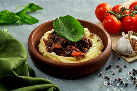 콘크리트 배경에 진흙 접시에 조림 고기를 곁들인 으깬 감자 0명에 대한 스톡 사진 및 기타 이미지 0명 감자 요리 고급