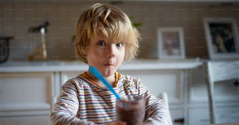 집에서 부엌에서 푸딩을 먹고 실내에서 더러운 입을 가진 작은 소년의 초상화 사진 Unsplash의 음식 이미지