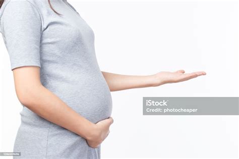 젊은 아름다운 임산부는 흰색 배경에 텍스트를 위해 열린 손 손바닥에 빈 복사 공간을 보여주는 배와 감동 임신 모성 사람 및 기대 개념 개념에 대한 스톡 사진 및 기타 이미지