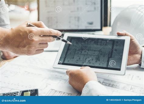 Engineer Meeting And Using Digital Tablet For Architectural Project And Working With Partner