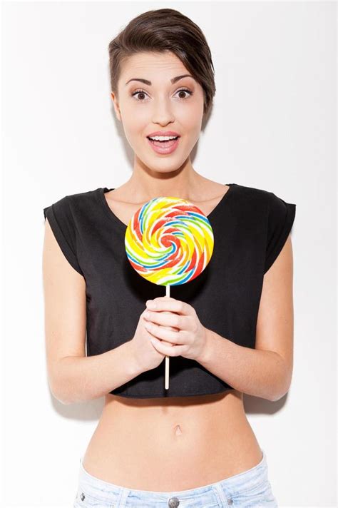Really Big Candy Surprised Young Short Hair Woman Holding A Big Lollipop And Staring At Camera