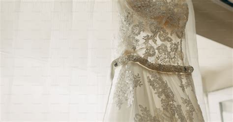 호텔 방의 창문 근처에 매달려 있는 아름다운 흰색 웨딩 드레스 아침 결혼식 준비 옷걸이 클로즈업에 신부를 위한 흰색 레이스