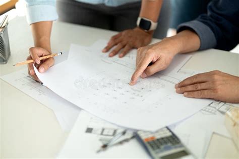 Engineers And Architects Are Looking At The Plans Of The Construction Project Consulting To Plan