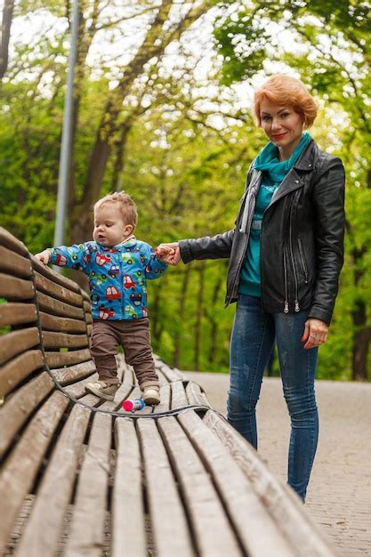 Hermosa Niña Madre Con Un Hijo En El Parque En El Parque Está Sentada En Un Banco Foto Premium
