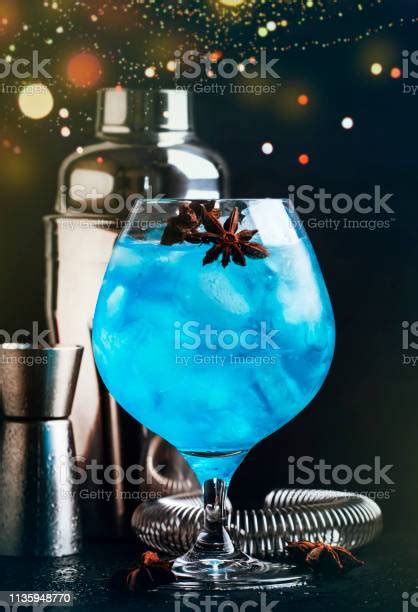 바텐더 철강 도구 블랙 바 카운터 배경 선택적 초점 큰 와인 유리에 삼 부 카 리큐 어 레몬 주스 분쇄 얼음과 아니 스 별과 블루 알콜 칵테일 0명에 대한 스톡 사진 및