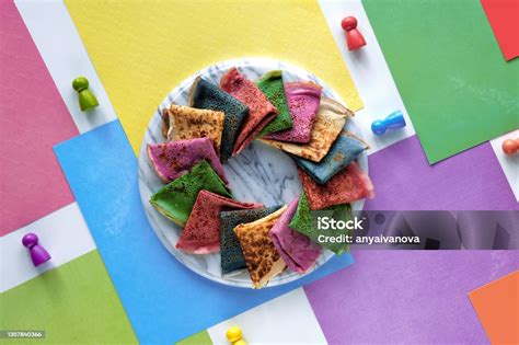 나무 그림과 겹쳐 진 무지개 종이 배경에 무지개 색의 크레페 접시 기하학적 플랫 평지 색상 빨간색 보라색 오렌지 녹색 노란색 크리에이티브 한 생생한 대담한 색상 음식 개념