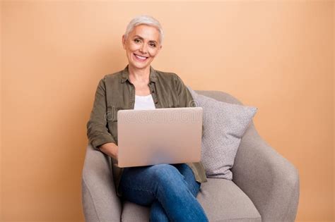 Photo Portrait Of Pretty Senior Female Sit Soft Armchair Hold Laptop