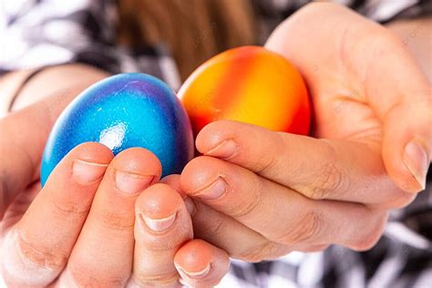 Eggs Of Different Colors Being Tapped And Crushed By Hands Photo