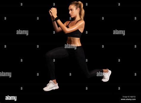 Girl Doing Split Squat Curl On Black Background Stock Photo Alamy