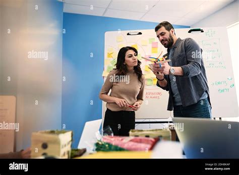 Male And Female Engineers Discussing Over Project At Table In Office