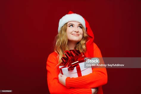 빨간 배경에 선물을 가진 산타클로스 모자를 쓴 아름다운 젊은 여성 12월에 대한 스톡 사진 및 기타 이미지 12월 개념 겨울 Istock