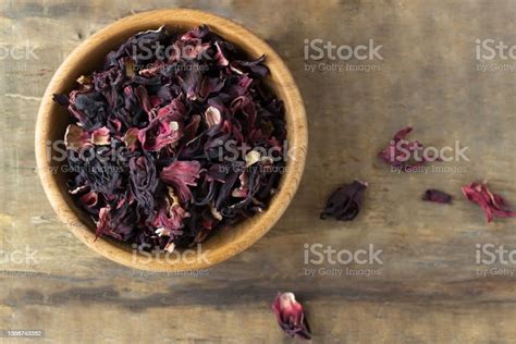 마른 히비스커스는 나무 테이블에 나무 그릇에 잎 맨 위 보기입니다 공간을 복사합니다 말린 로젤라 또는 수단 장미 꽃 그것은 아랍 국가에서 매우 인기가 있습니다 그들은 적갈색