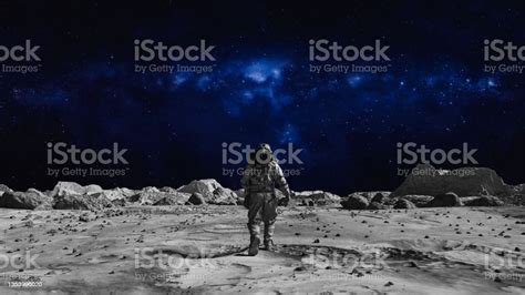 우주복을 입은 용감한 우주비행사의 촬영에 이어 바위로 뒤덮인 은하수를 향해 달 표면을 자신있게 걷고 있다 달 표면에 첫 번째 우주 비행사 첨단 기술 우주 탐사 여행 식민지