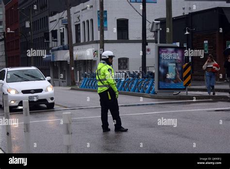 A Police Officer Standing At The Intersection Of The Street To Regulate Traffic In Vancouver