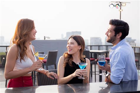 그룹 친구들은 칵테일을 마시고 레스토랑에서 파티를 응원하며 함께 즐거운 시간을 보내고 남자와 여자가 만나 음료를 마시고 라이프 스타일 개념을 함께 축하합니다 공휴일에 대한