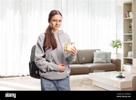 Female Teenager With Eating Disorder Holding A Sandwich At Home Stock