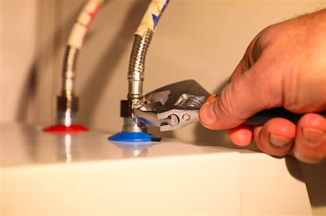 조정 가능한 렌치 및 기타 도구를 사용하여 숙련 된 배관공이 온수 및 냉수 호스를 보일러에 연결합니다 Diy에 대한 스톡 사진 및 기타 이미지 Istock