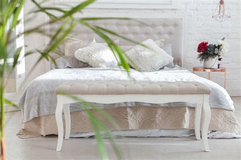 Luxurious 밝은 색상 클래식 절충 주의 스타일의 침실 킹 사이즈 침대와 침대 옆 테이블 녹색 식물 및 거울 라이트 코트와 베개 홈 Coziness를 만듭니다 가정