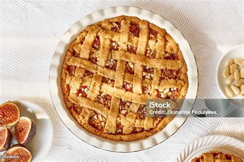 쿠키 크러스트 베이스를 곁들인 수제 무화과 타르트 흰색 식탁보가있는 테이블에 무화과와 아몬드가있는 쇼트 브레드 파이 가을 베이킹 맨 위 보기입니다 과일에 대한 스톡 사진 및