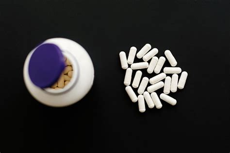 검은 어두운 배경에 병 항아리에 마그네슘 캡슐과 흰색 알약 플랫 레이 식이 보조 제 백색 알약 건강 지원 및 치료 생물학적 활성 첨가제 0명에 대한 스톡 사진 및 기타