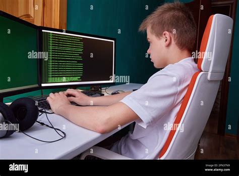 A Young Programmer Guy Prints The Program Code On The Computer Monitor Screen The Concept Of