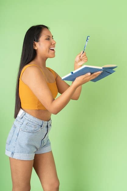 Premium Photo Studio Portrait With Green Background Of A Creative Woman Writing Ideas On A
