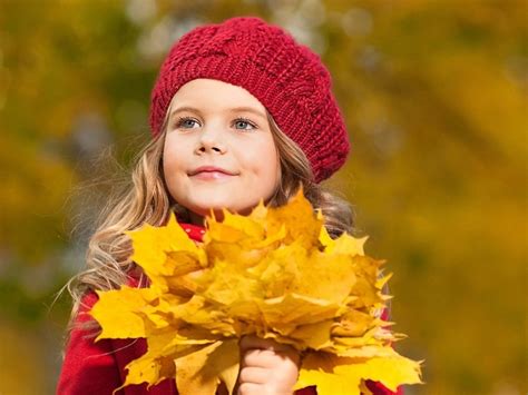 Фото Девочка держит в руках букет из желтых листьев