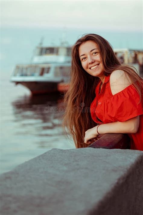 Όμορφο σέξι κορίτσι με κόκκινο φόρεμα με μεγάλα μαλλιά Γυναίκα που περπατάει στο σπίτι το βράδυ