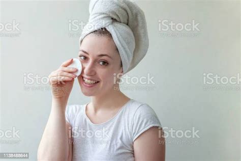 흰색 배경에 고립 된 면 패드를 사용 하 여 부드러운 건강 한 피부 제거와 머리에 수건에서 웃는 여자 건강한 생활방식에 대한 스톡 사진 및 기타 이미지 Istock