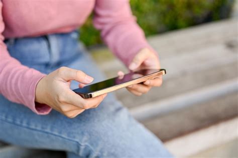 Premium Photo Woman Using Her Smartphone To Play Mobile Game While Sitting At The Bench In The Premium Photo Woman Using Her Smartphone To Play Mobile Game While Sitting At The Bench In The