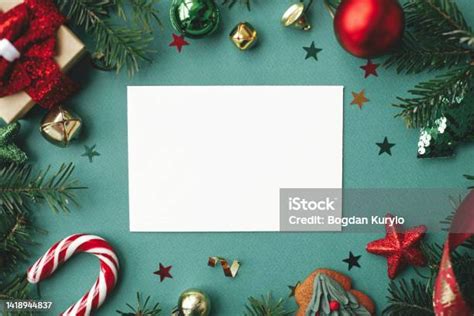 크리스마스 카드 모형 현대적인 인사말 카드 플랫은 녹색 배경에 세련된 크리스마스 장식과 전나무 가지로 놓여 있습니다 텍스트 공간이 있는 빈 엽서 템플릿입니다 즐거운 성탄절