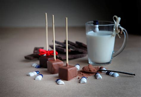 밀크 컵과 향기로운 코코아와 갈색 배경에 초콜릿 을 곁들인 초콜릿 큐브 와 카카오 숟가락 근처의 작은 눈사람 곡초류에 대한 스톡 사진 및 기타 이미지 Istock