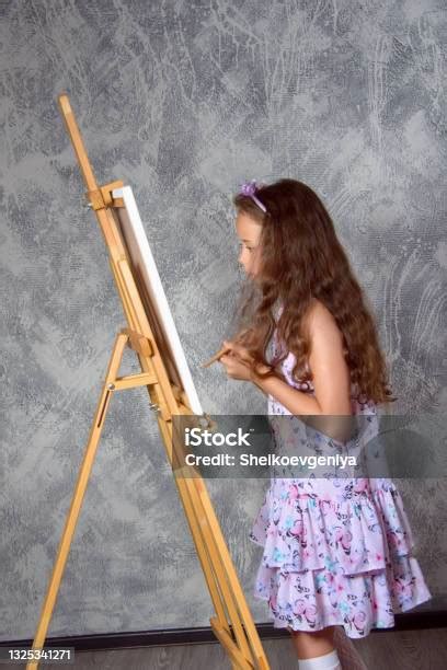 크리에이티브 걸 아티스트가 스튜디오의 이젤에 새로운 그림을 그립니다 재능있는 아이는 스튜디오 또는 예술 학교에 있습니다 고등학교 이하에 대한 스톡 사진 및 기타 이미지