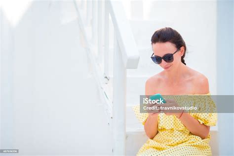 좁은 오래 된 거리에 야외에서 스마트폰으로 여자 관광 모바일 스마트폰을 사용 하 여입니다 Brand Name Online Messaging Platform에 대한 스톡 사진