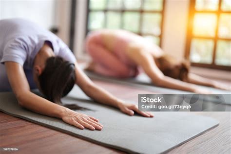 아시아 여성들은 피트니스 스튜디오에서 요가 수업에서 어깨를 이완하고 강화하기 위해 포즈를 취합니다 요가 피트니스 스튜디오에서 운동하는 아시아 여성들 체육관에 대한 스톡 사진