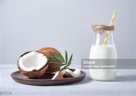 파란색 배경에 나무 접시에 절반 코코넛과 야자 수 분지와 건강한 채식 우유 병 전면 보기 및 복사 공간 0명에 대한 스톡 사진 및 기타 이미지 Istock
