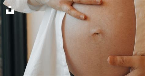 배에 손을 얹고 있는 임산부 사진 Unsplash의 무료 갈색 이미지