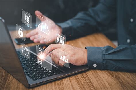 문서 관리 및 기술 개념 사업가는 사무실과 어두운 시멘트 벽 배경에서 작동하는 가상 화면의 아이콘이있는 노트북 컴퓨터를 사용합니다 Brand Name Smart Phone에