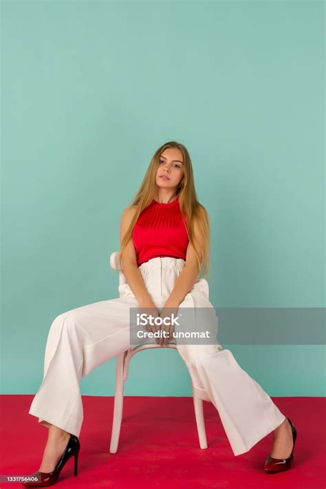 예쁜 빨간 탱크 탑 흰색 바지 파란색 배경 위에 포즈를 취하는 하이힐을 입은 아름다운 우아한 젊은 여성의 패션 사진 명랑한에 대한 스톡 사진 및 기타 이미지 Istock