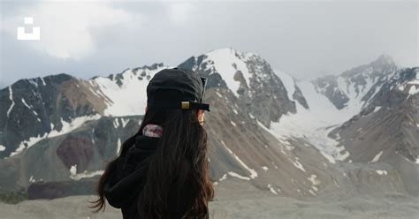 검은 재킷과 검은 니트 모자를 쓴 여자가 갈색 들판에 서서 눈 덮인 것을 보고 있다 사진 Unsplash의 무료 알타이 타반 복드 국립공원 이미지