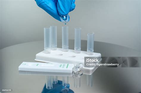 항원 신속 검사를 위해 추출 완충 튜브에 시약을 떨어뜨리는 간호사 금속 의료 테이블에 플라스틱 튜브 및 테스트 카세트 세트 의료